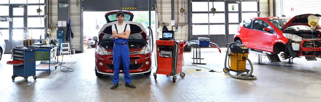 car mechanic in a garage with vehicles // moderne Autowerkstatt ...